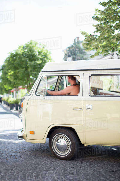 Man driving mini van on street - Stock Photo - Dissolve