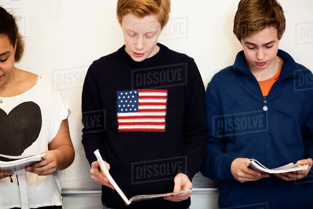 High school students reading book against whiteboard - Stock Photo ...