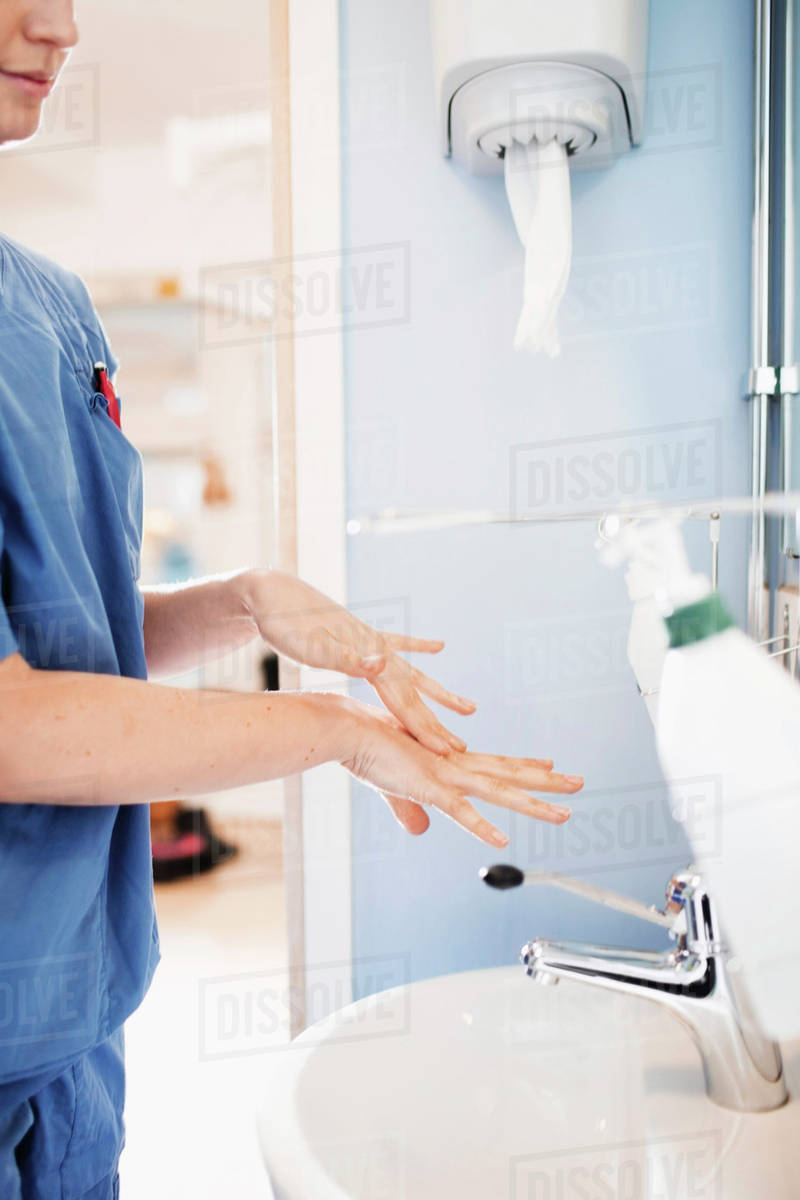 Side view of young nurse washing hands in hospital bathroom - Royalty ...