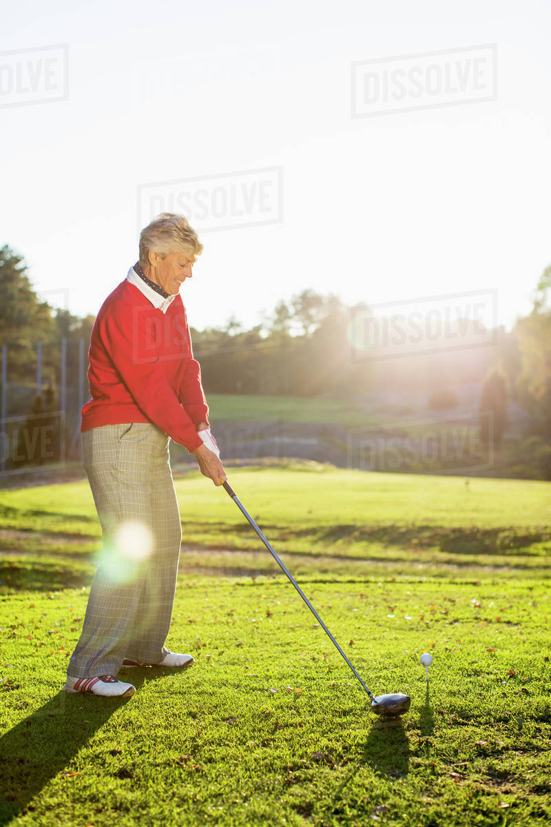 Full length side view of senior woman playing golf on course - Stock ...