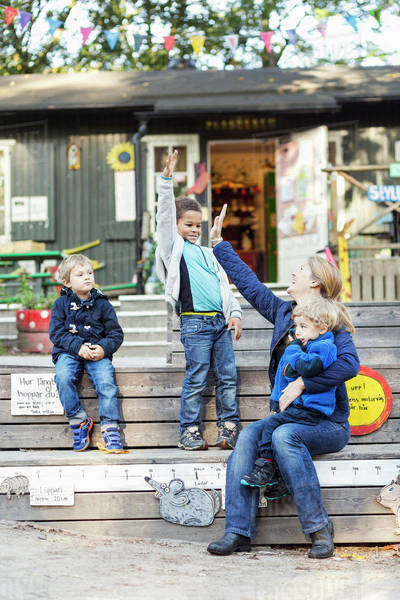 Happy teacher giving high-five outside preschool building - Stock Photo ...