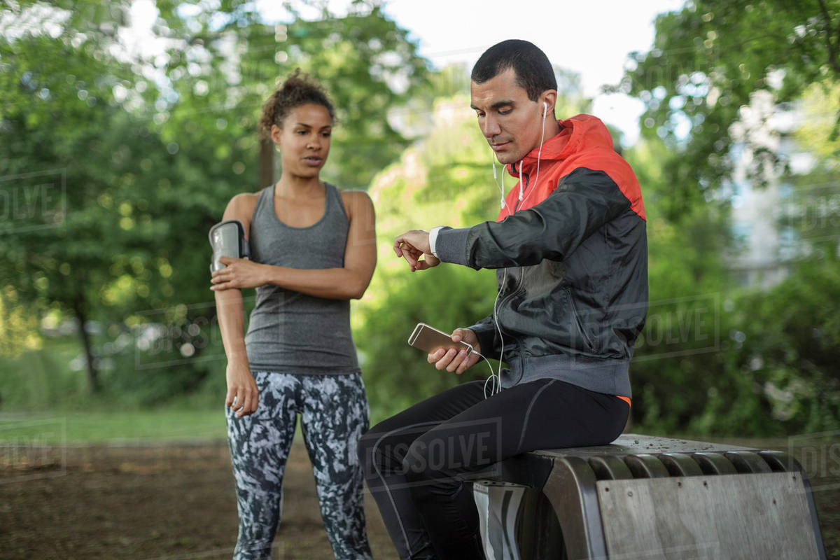 Man looking at wristwatch while woman touching arm band - Stock Photo ...