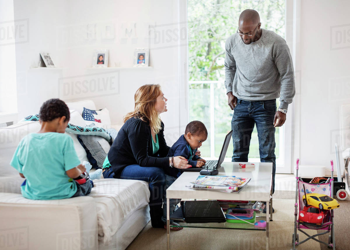 Multi-ethnic family in living room at home - Stock Photo - Dissolve
