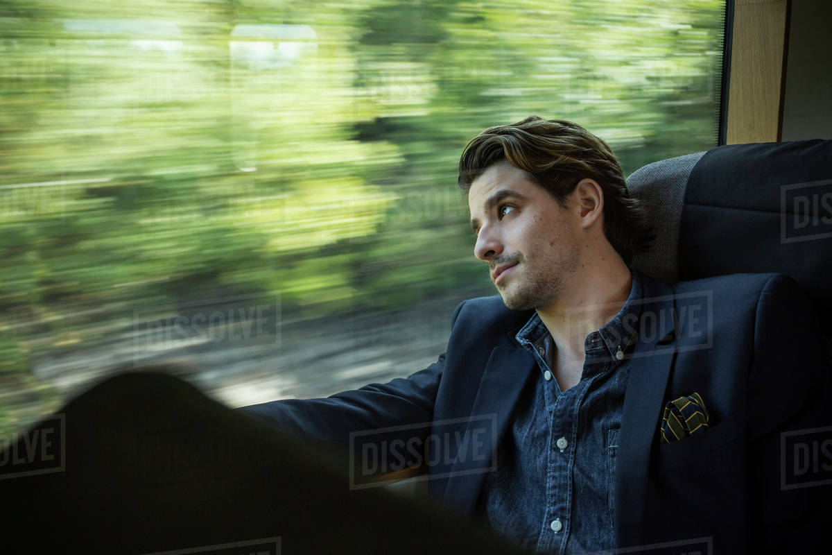 Businessman looking out through train window - Stock Photo - Dissolve