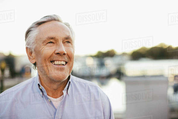 Thoughtful senior man looking up and smiling outdoors - Royalty-free ...