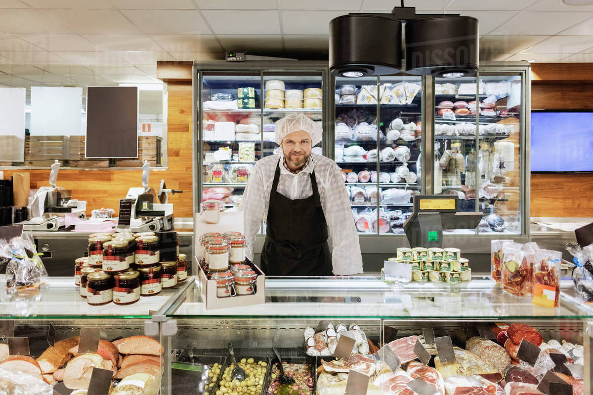 Portrait of smiling sales clerk standing in supermarket - Royalty-free ...