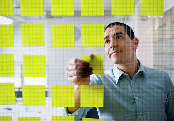 Man attaching post-it - Royalty-free Stock Photo | Dissolve