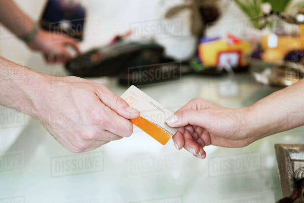 Two hands and a credit card - Stock Photo - Dissolve