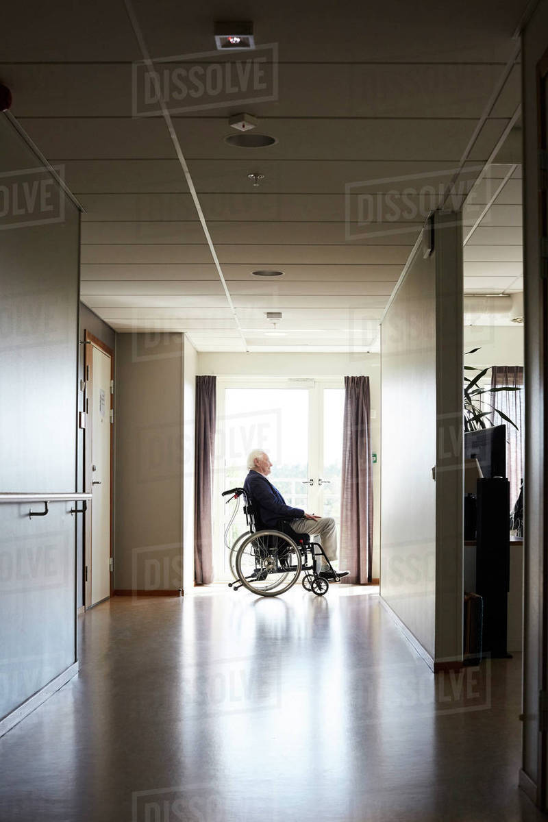 Side view of senior male patient sitting in wheelchair at hospital ...