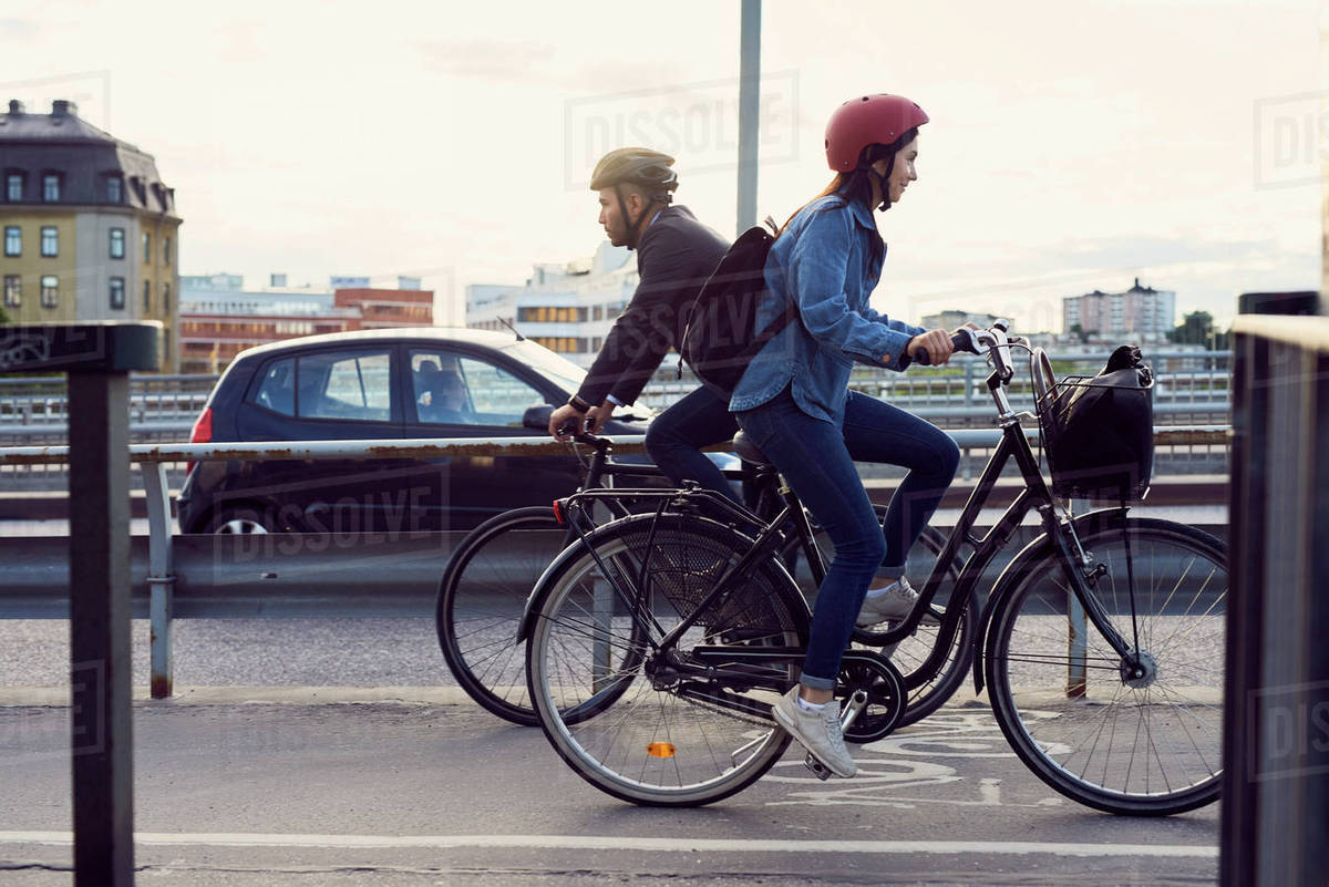 Side view of people cycling on street against sky - Royalty-free Stock ...