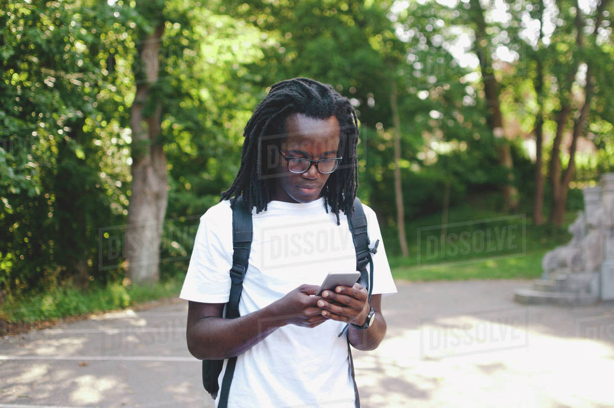 Young university student using mobile phone outside university - Stock ...
