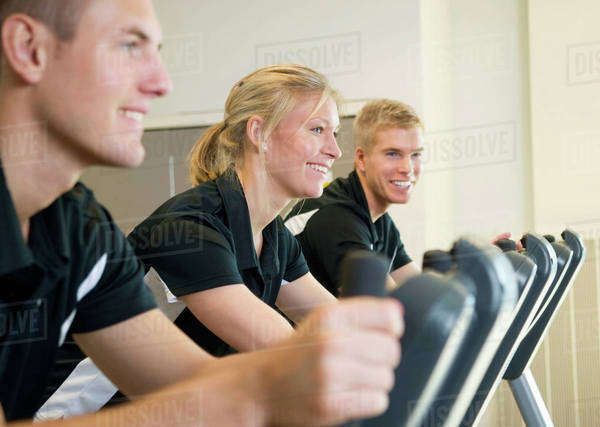Three smiling people working out - Royalty-free Stock Photo | Dissolve