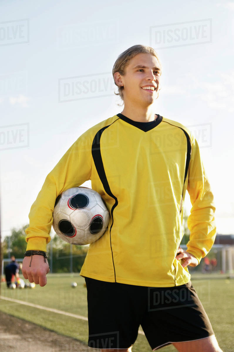 Guy posing with football - Royalty-free Stock Photo | Dissolve