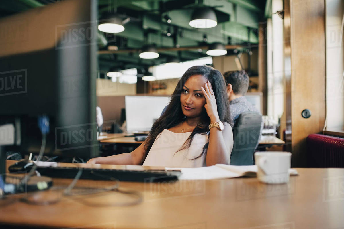 Concentrated businesswoman looking at computer monitor in office ...