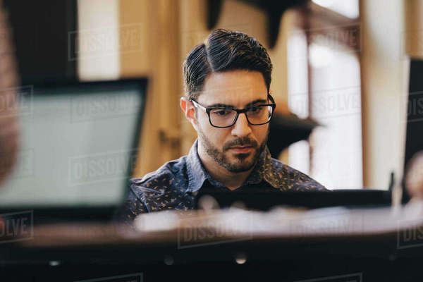 Businessman wearing glasses while working in creative office - Royalty ...