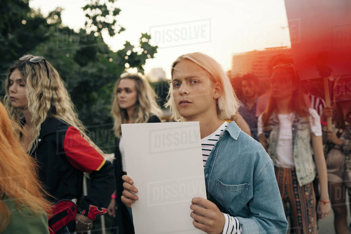 Portrait of young man with friends protesting in city - Royalty-free ...