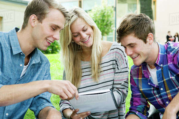 Three students sitting outdoors - Royalty-free Stock Photo | Dissolve