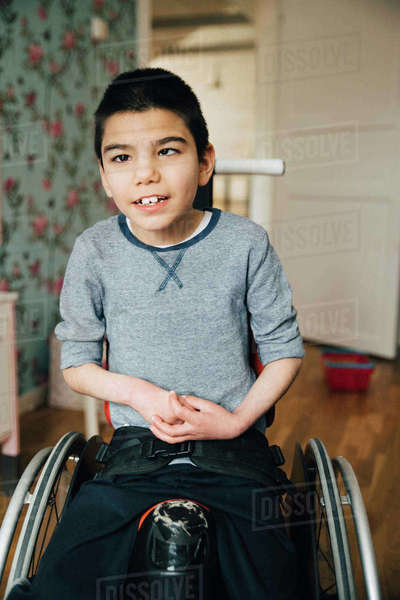 Portrait of autistic boy sitting on wheelchair at home - Stock Photo ...