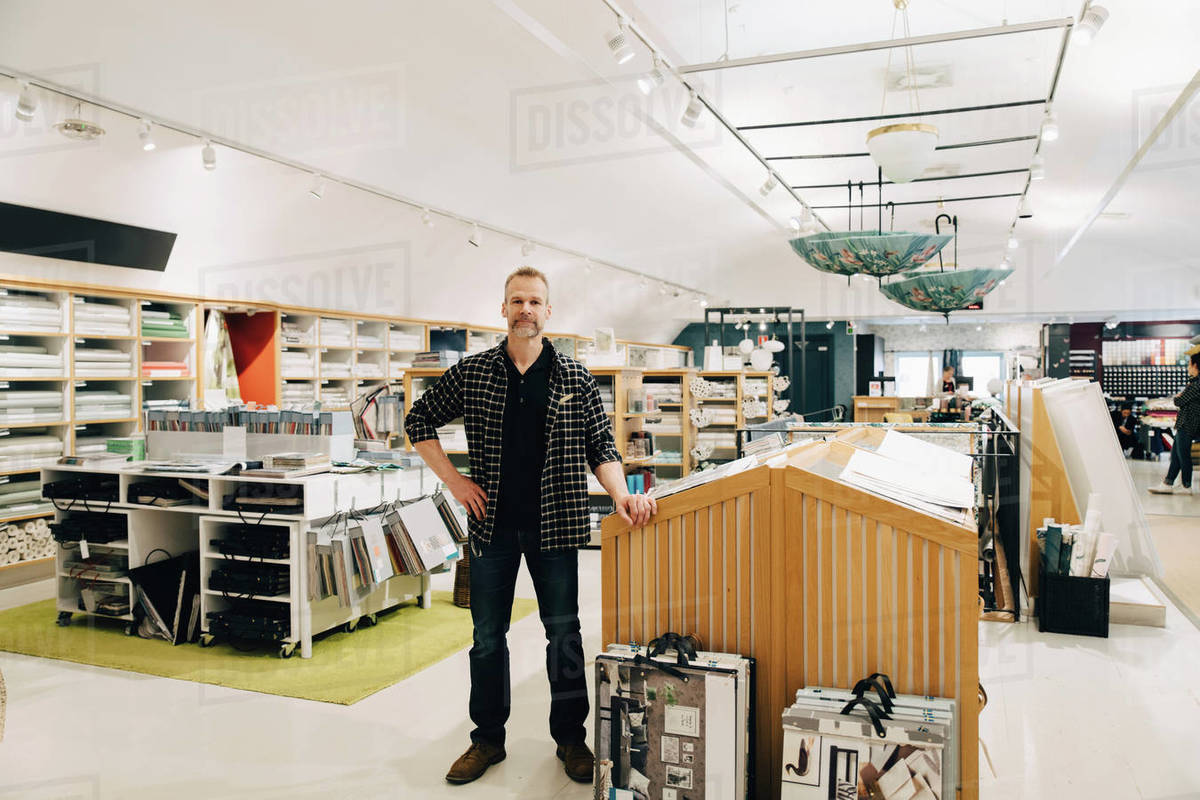 Full length portrait of man standing in store - Stock Photo - Dissolve
