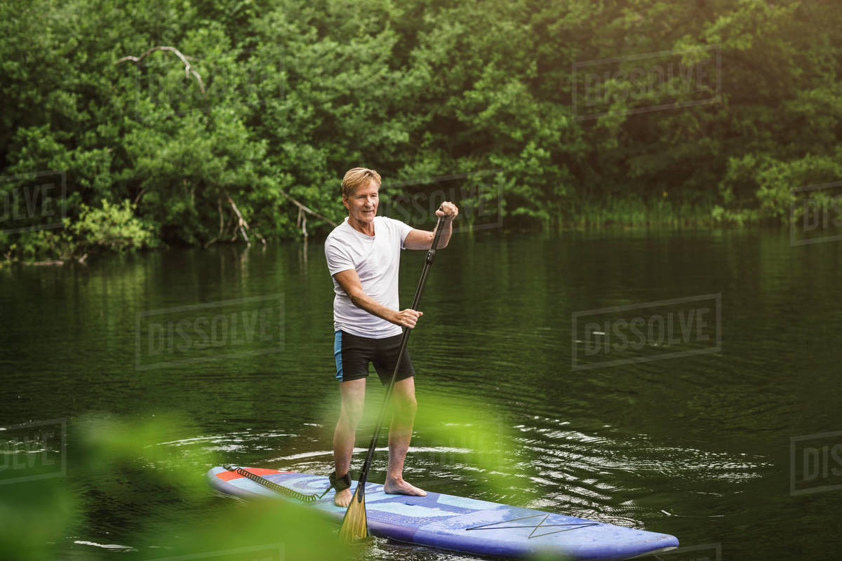 Senior man paddleboarding in sea during SUP course - Royalty-free Stock ...