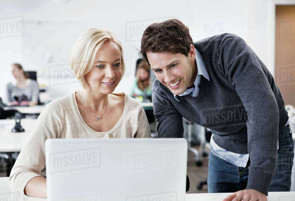 Colleagues helping each other by the computer - Royalty-free Stock ...