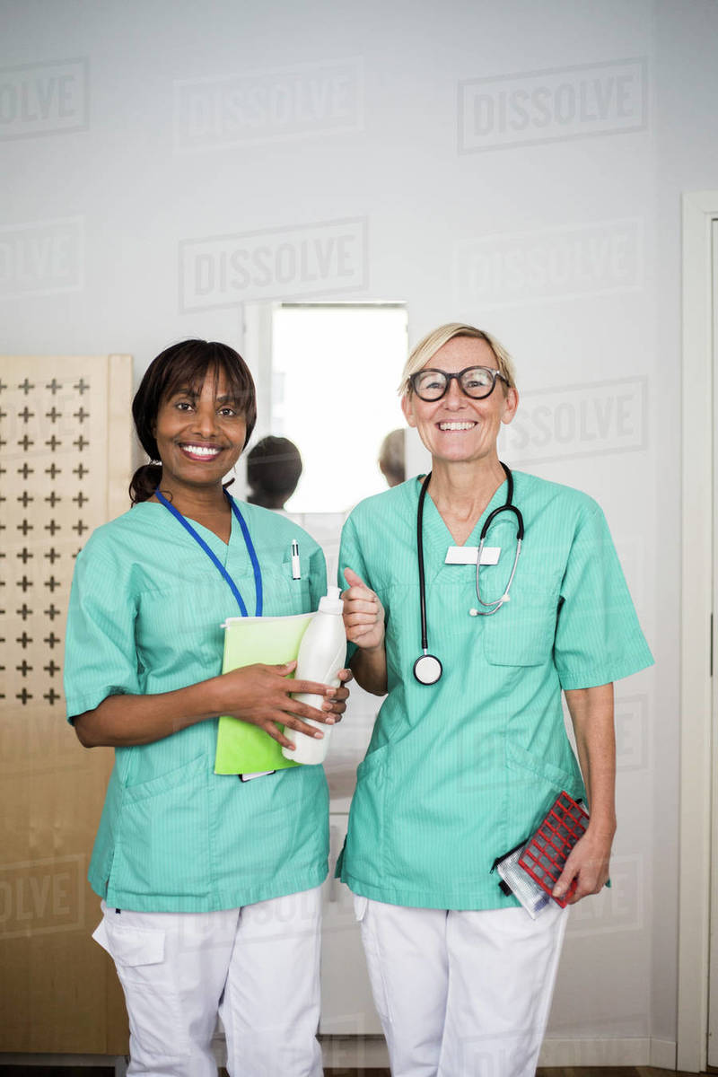 Portrait of smiling female healthcare workers standing in clinic ...