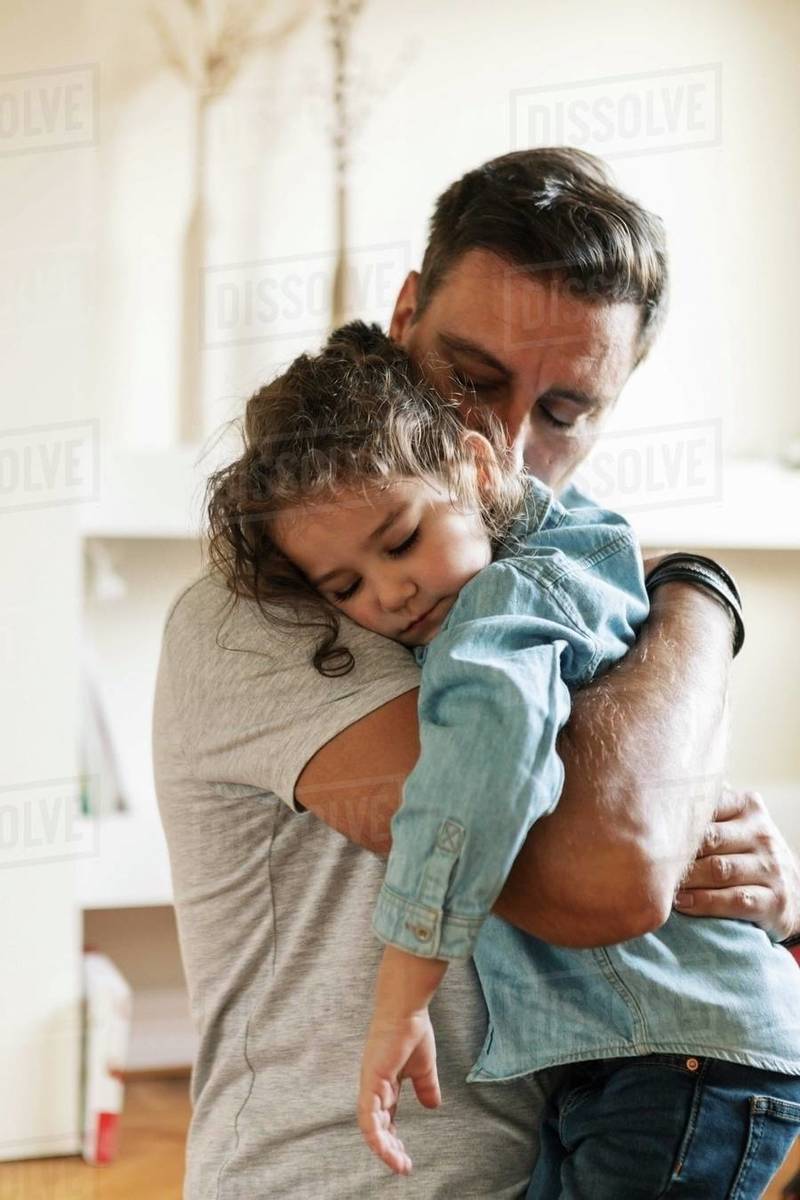 Father embracing sad daughter while standing at home - Stock Photo ...