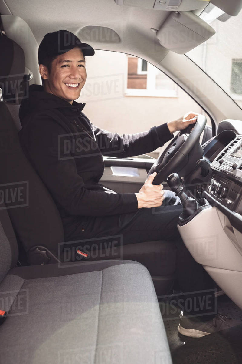 Portrait of happy driver sitting in truck - Royalty-free Stock Photo ...