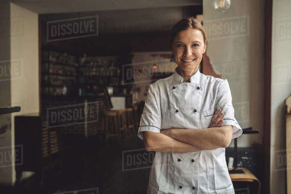 Portrait of smiling chef with arms crossed in restaurant - Stock Photo ...
