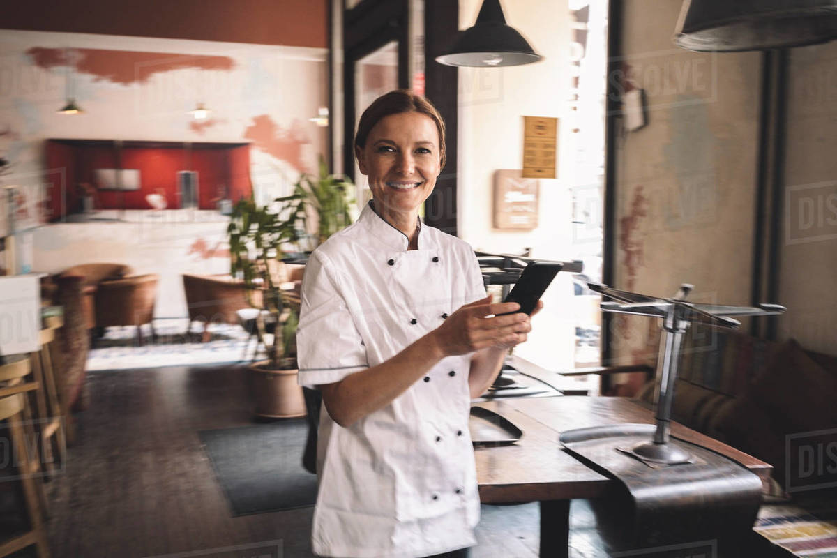 Portrait of smiling chef with smart phone in restaurant - Royalty-free ...