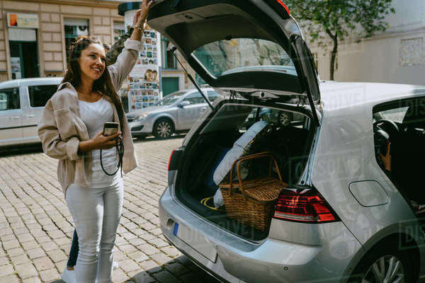 Mature woman standing by car trunk at roadside - Royalty-free Stock ...