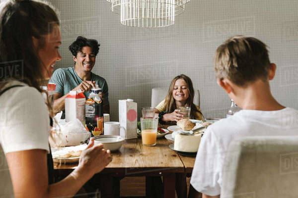 Happy family having breakfast on dining table at home - Royalty-free ...