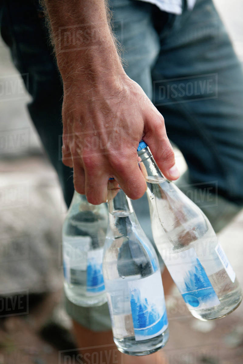 Hand holding bottles - Royalty-free Stock Photo | Dissolve