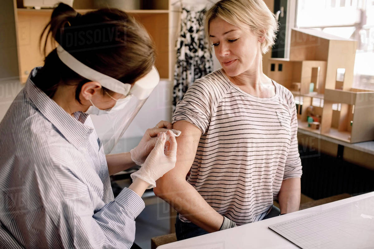 Female nurse injecting medicine to blond woman at home - Royalty-free ...