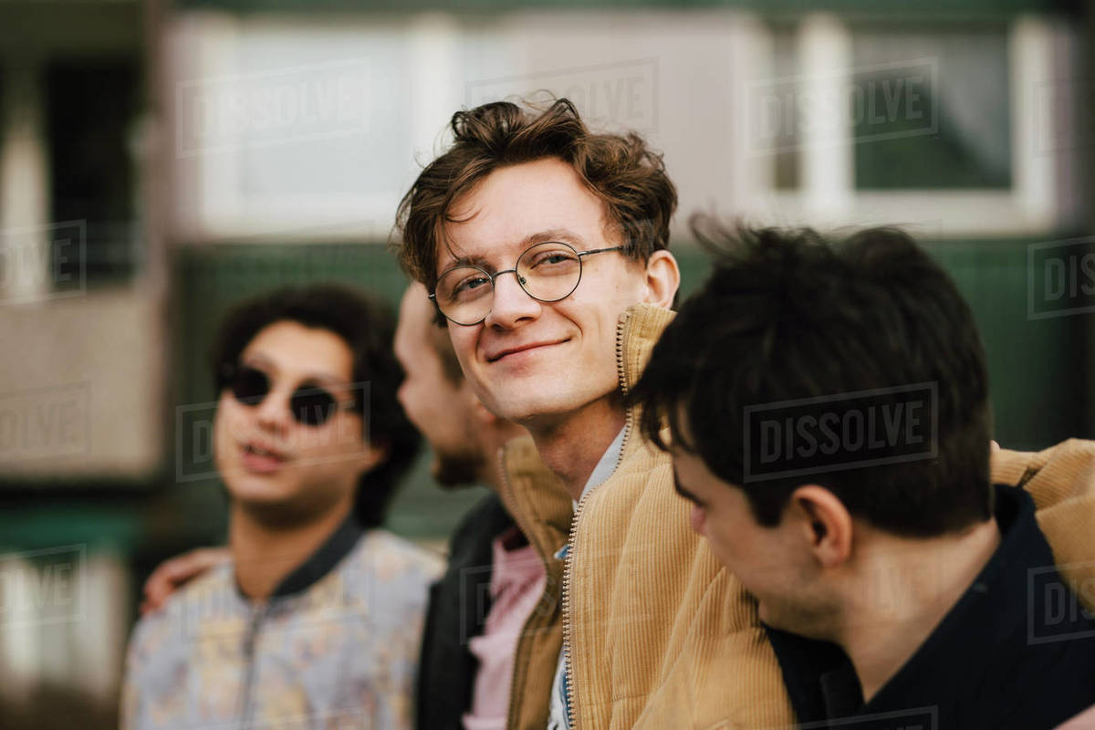 Portrait of smiling young man with male friends - Royalty-free Stock ...