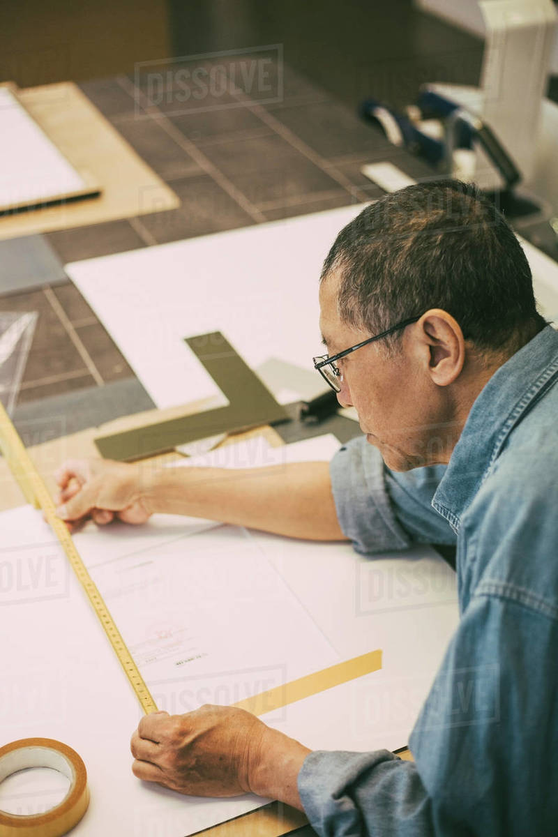 Craftsman measuring paper while working in office - Royalty-free Stock ...