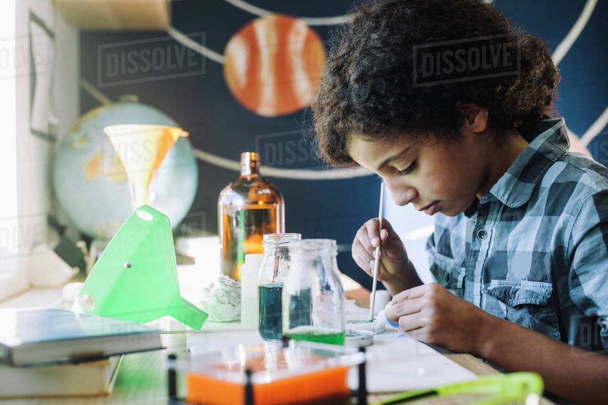 Girl concentrating while doing science project at home - Stock Photo ...