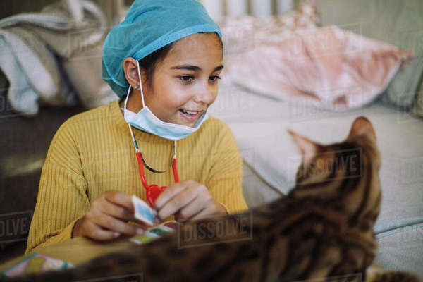 Smiling girl taking care of cat in living room - Royalty-free Stock ...