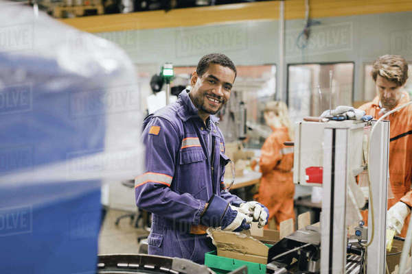 Portrait of smiling male blue-collar worker working in industry ...