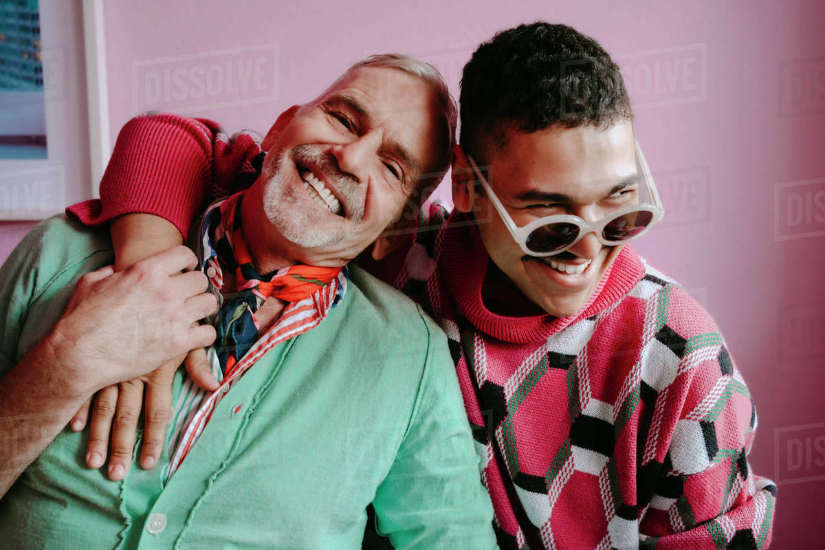 Happy gay man with arm around mature friend at home - Royalty-free ...