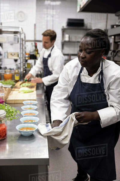Chef cleaning kitchen counter while working in commercial kitchen ...