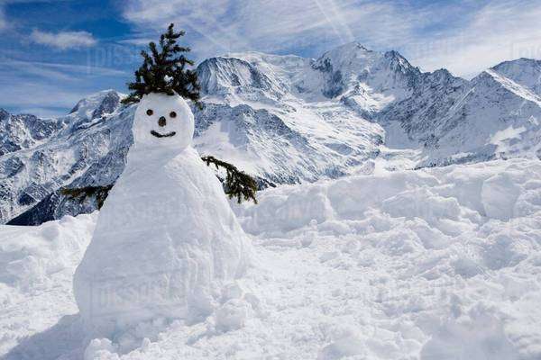 A snowman with mountains behind - Stock Photo - Dissolve