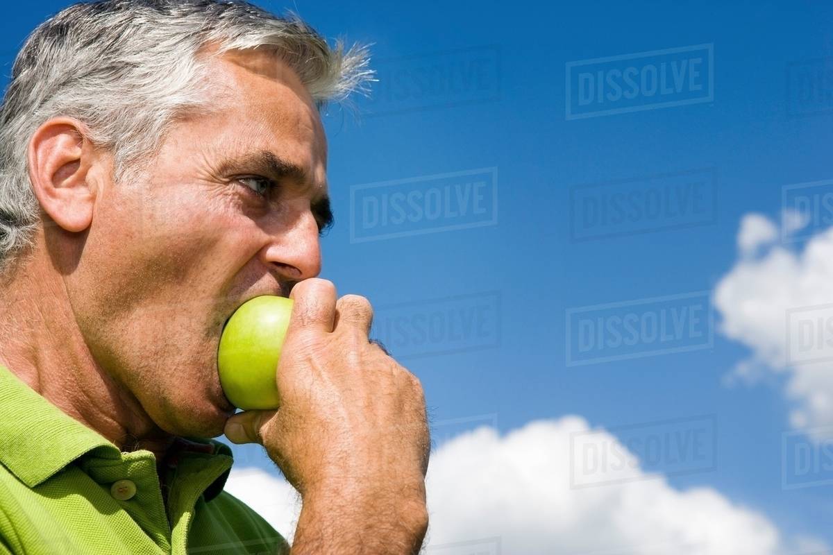 Man biting into apple - Stock Photo - Dissolve