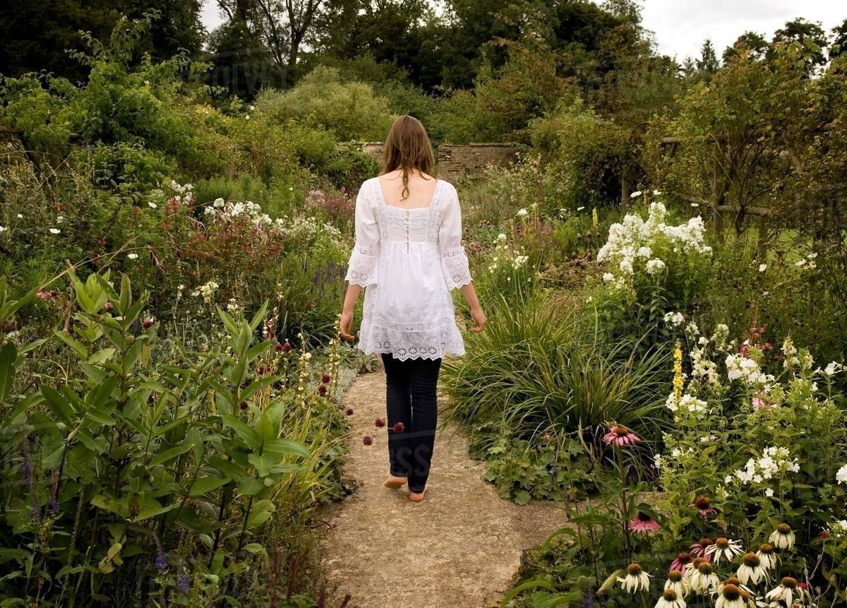 A female walking through a garden - Royalty-free Stock Photo | Dissolve