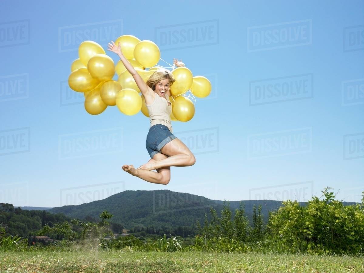 Girl jumping with balloons - Royalty-free Stock Photo | Dissolve