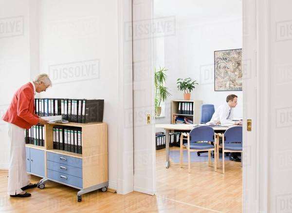 Woman looking through files - Stock Photo - Dissolve