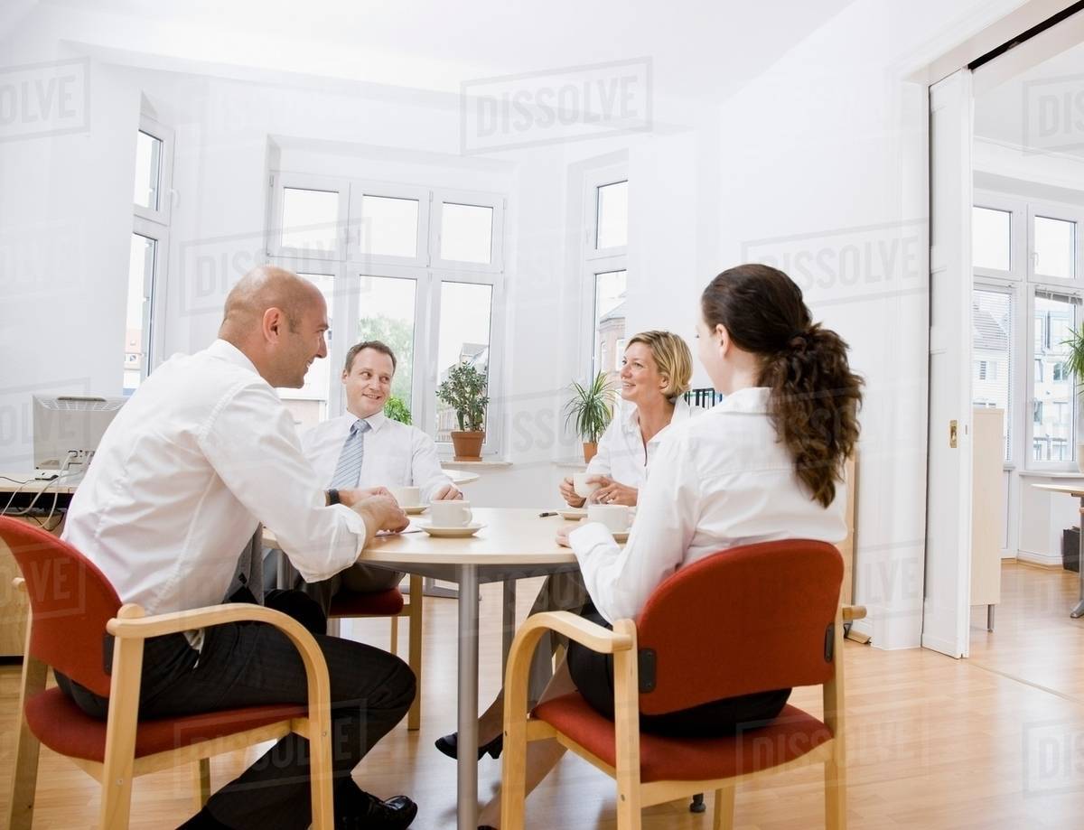 Coworkers talking over a meeting - Stock Photo - Dissolve