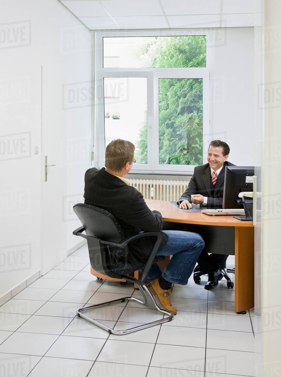 Co-workers at desk in office - Stock Photo - Dissolve