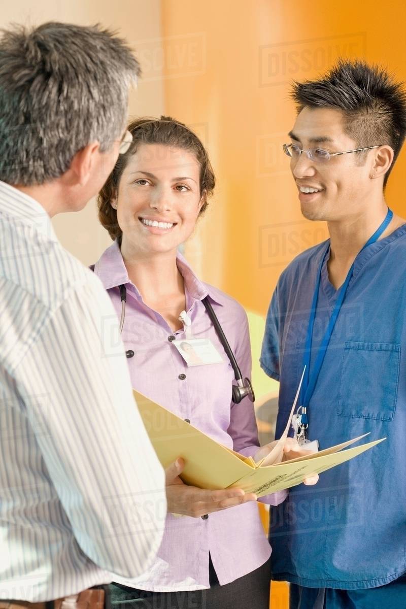 Three medical colleagues talking - Stock Photo - Dissolve