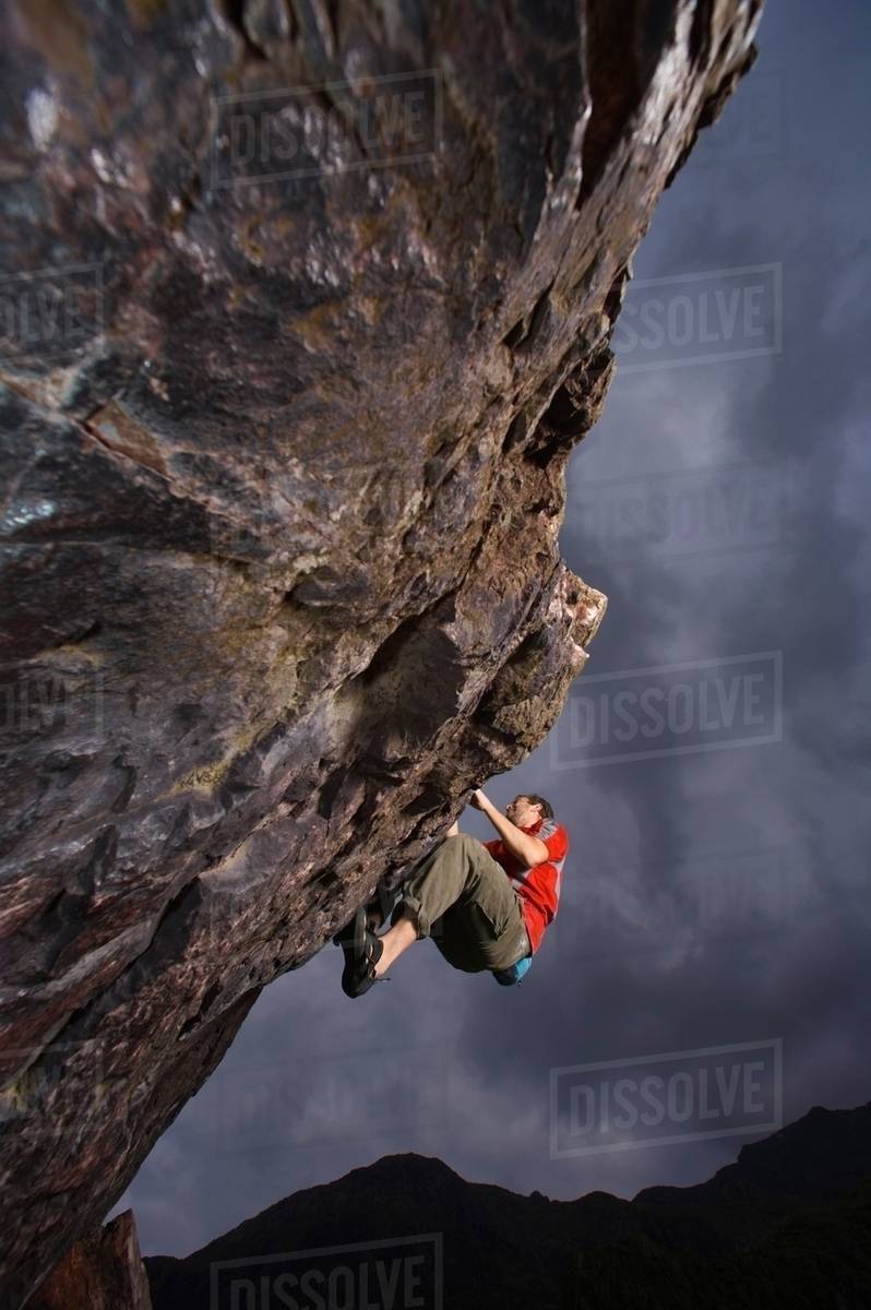 Climber bouldering on a rock face. - Royalty-free Stock Photo | Dissolve